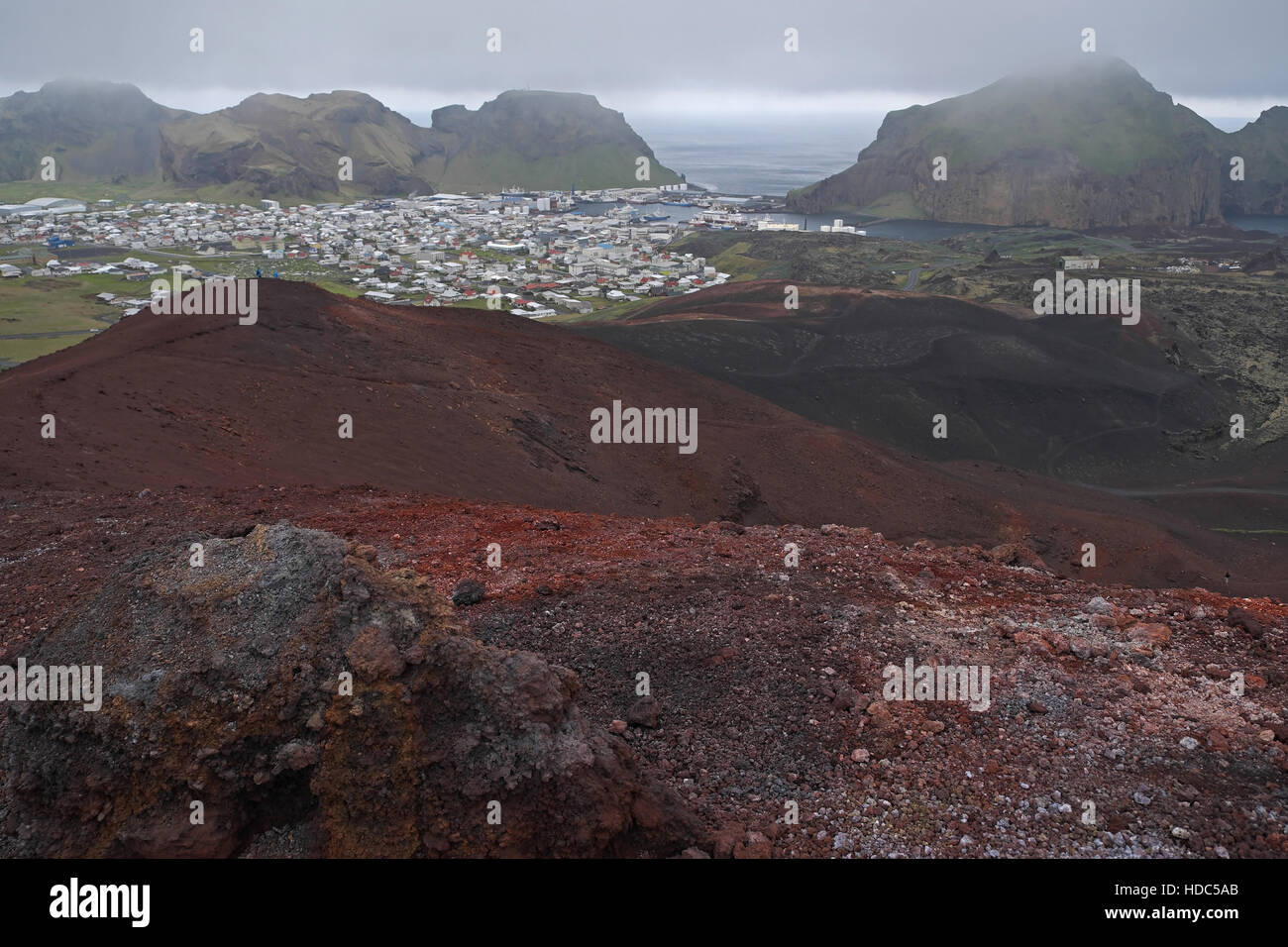 Village of Heimaey seen over volcanic rocks and lava field from Eldfell ...