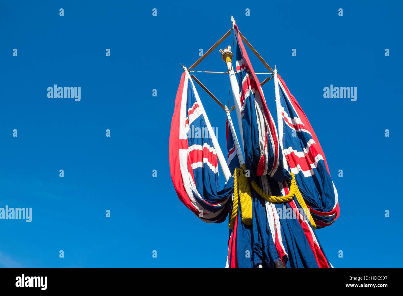 Ceremonial Union Jack British flags hang draped on a pole in bright ...