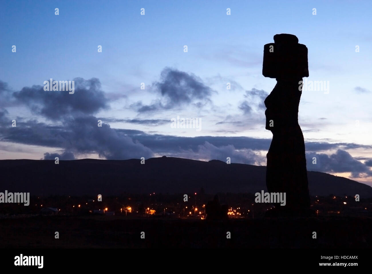 Ancient moai at Ahu Tahai overlooking night lights of modern Hanga Roa ...