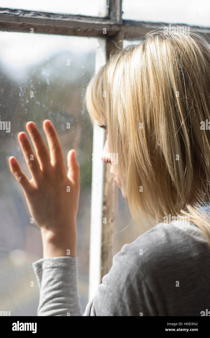 Sad woman by the window Stock Photo - Alamy