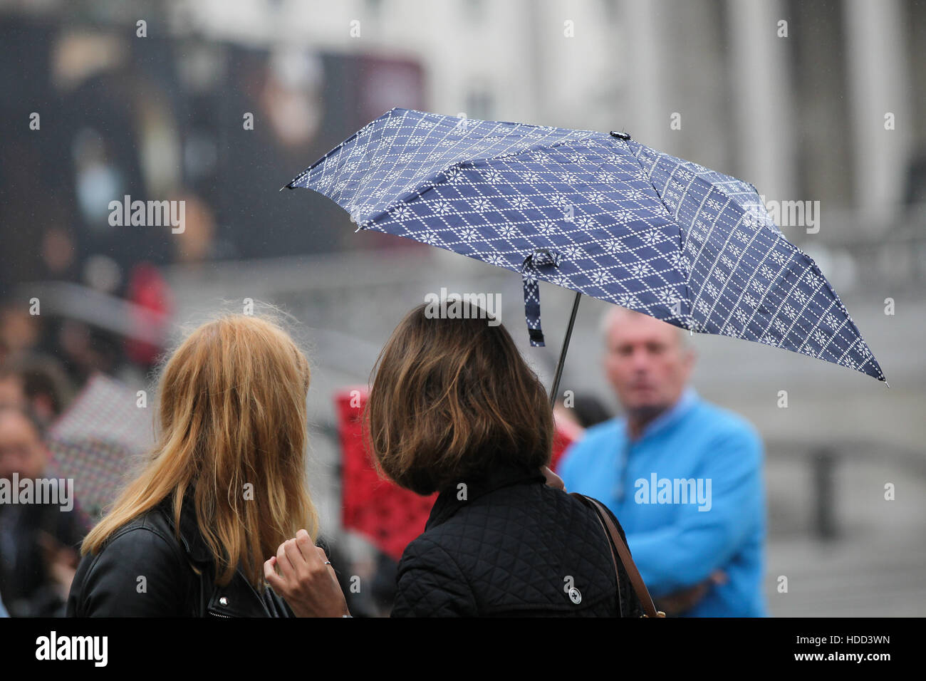 People in heavy rain and windy conditions in Trafalgar Square, London ...