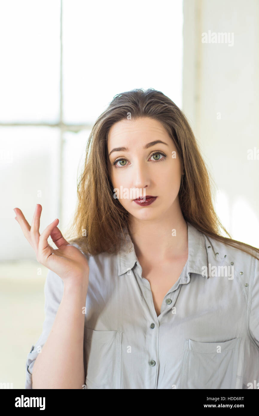 Beautiful young woman showing a confused expression Stock Photo - Alamy