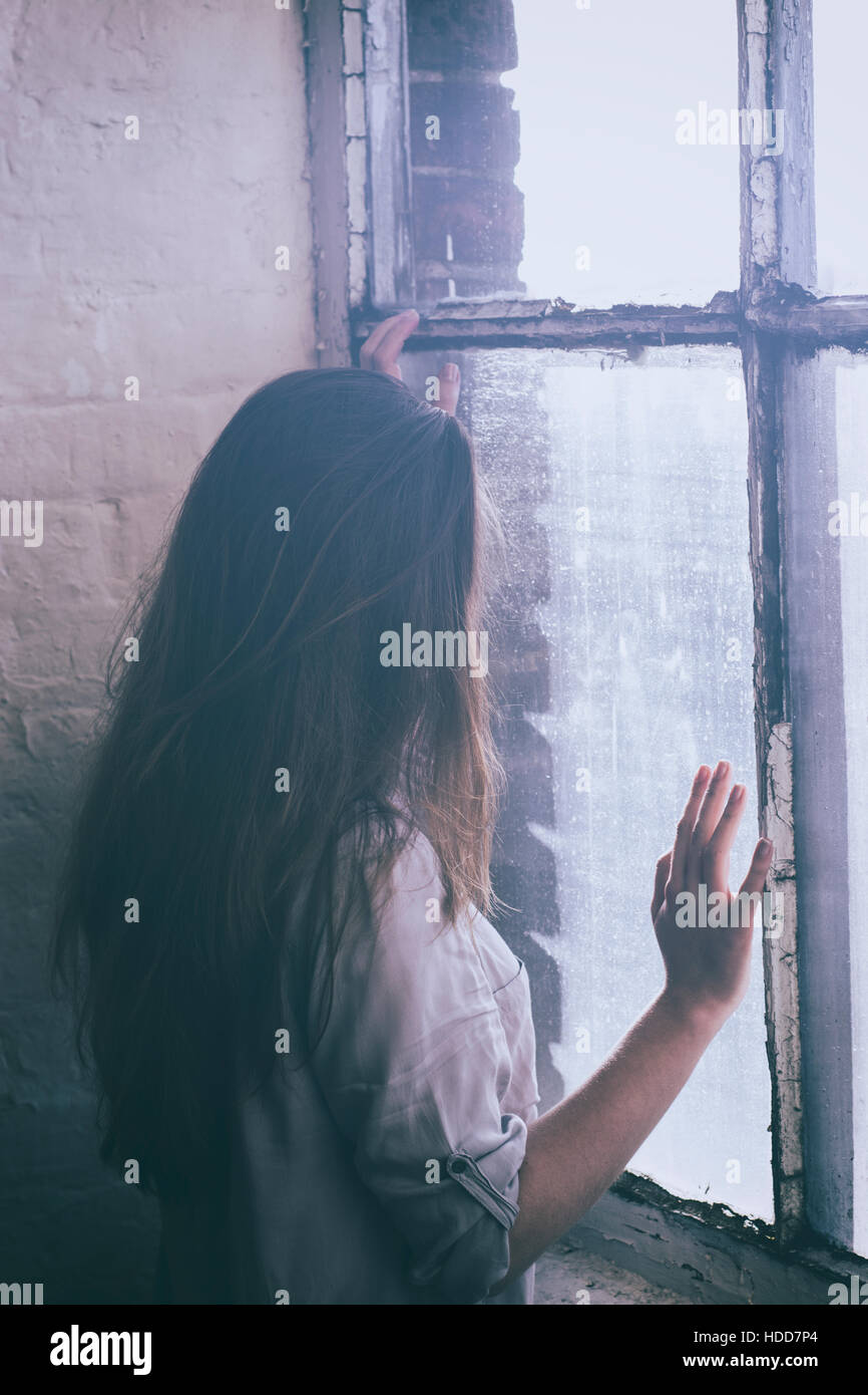 Woman looking out of the window Stock Photo - Alamy