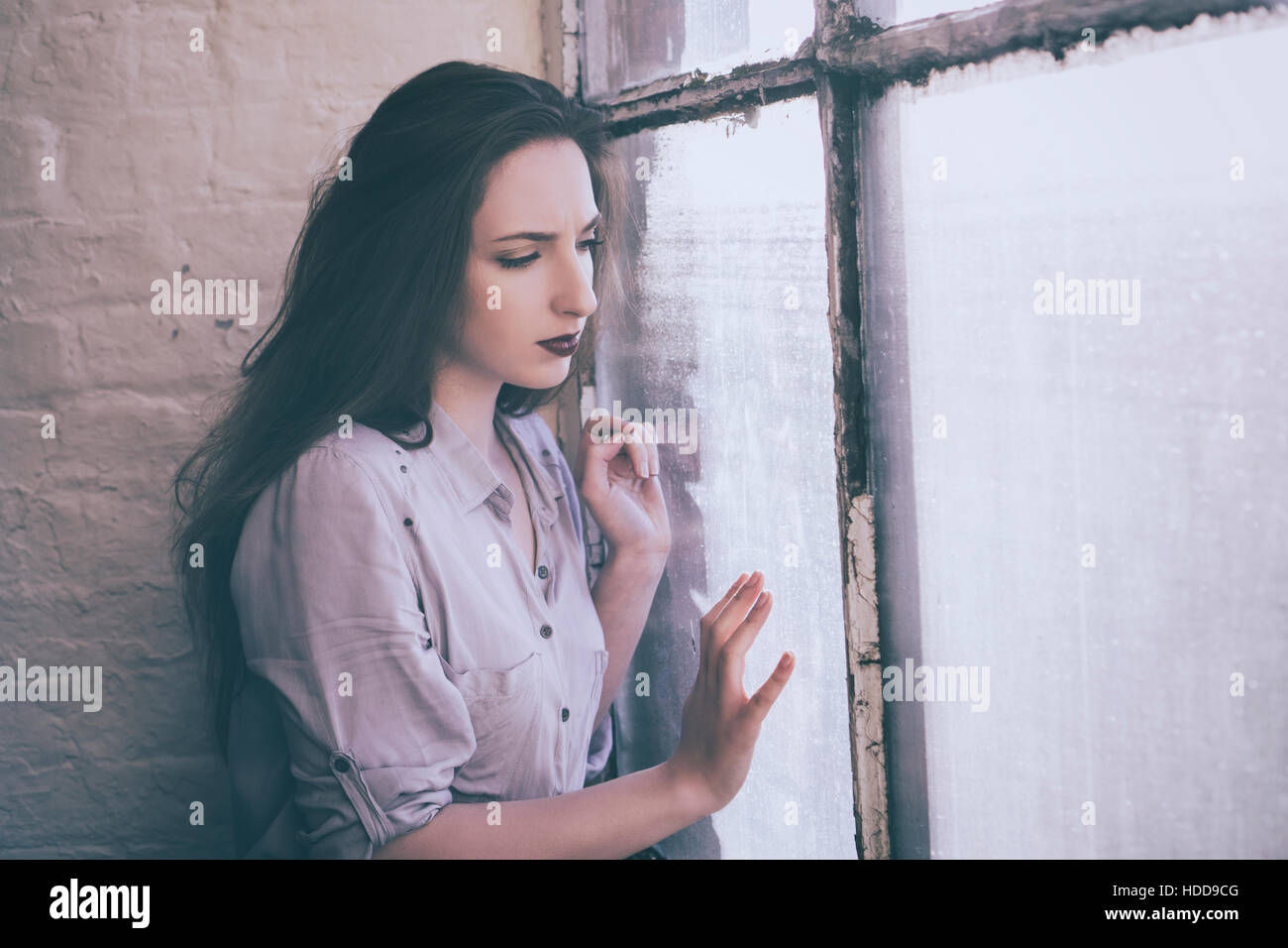 Upset woman looking out of the window Stock Photo - Alamy