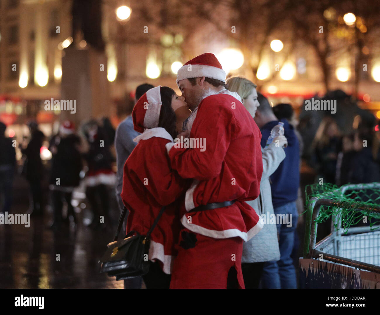 A couple of revellers kissing in Trafalgar Square, London, whilst ...