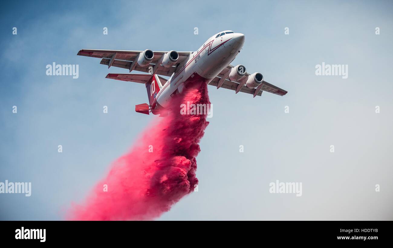 An aircraft drops pink-colored fire retardant on the Cedar Fire while ...
