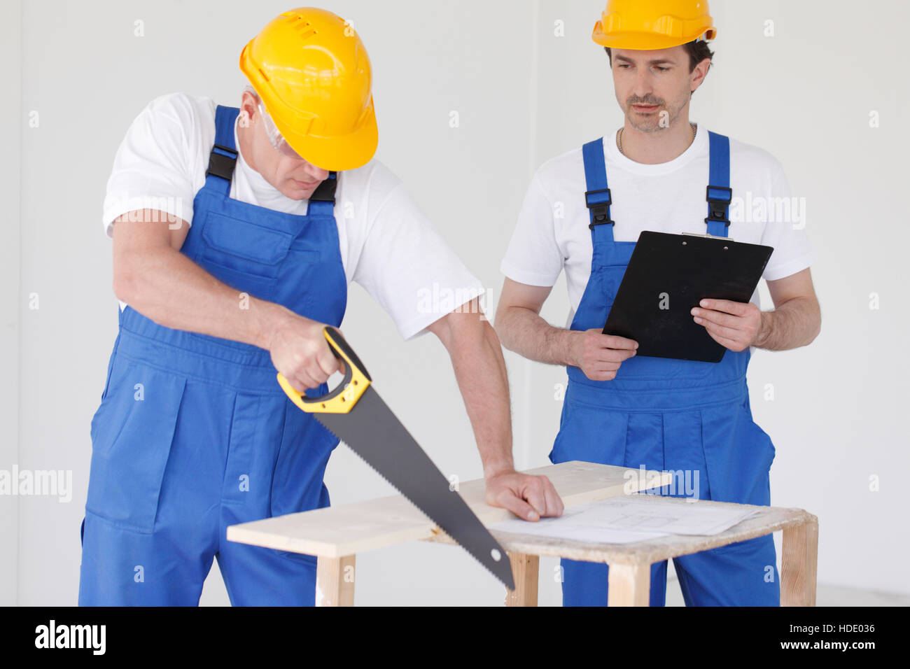 Male worker sawing a wooden board at work Stock Photo - Alamy