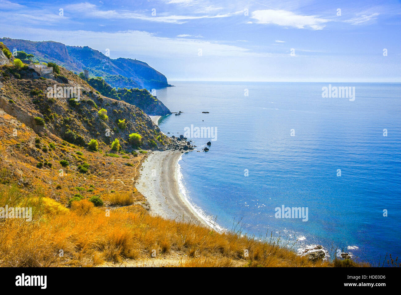 the rocky coastline with small beaches and ruined tower between Nerja ...