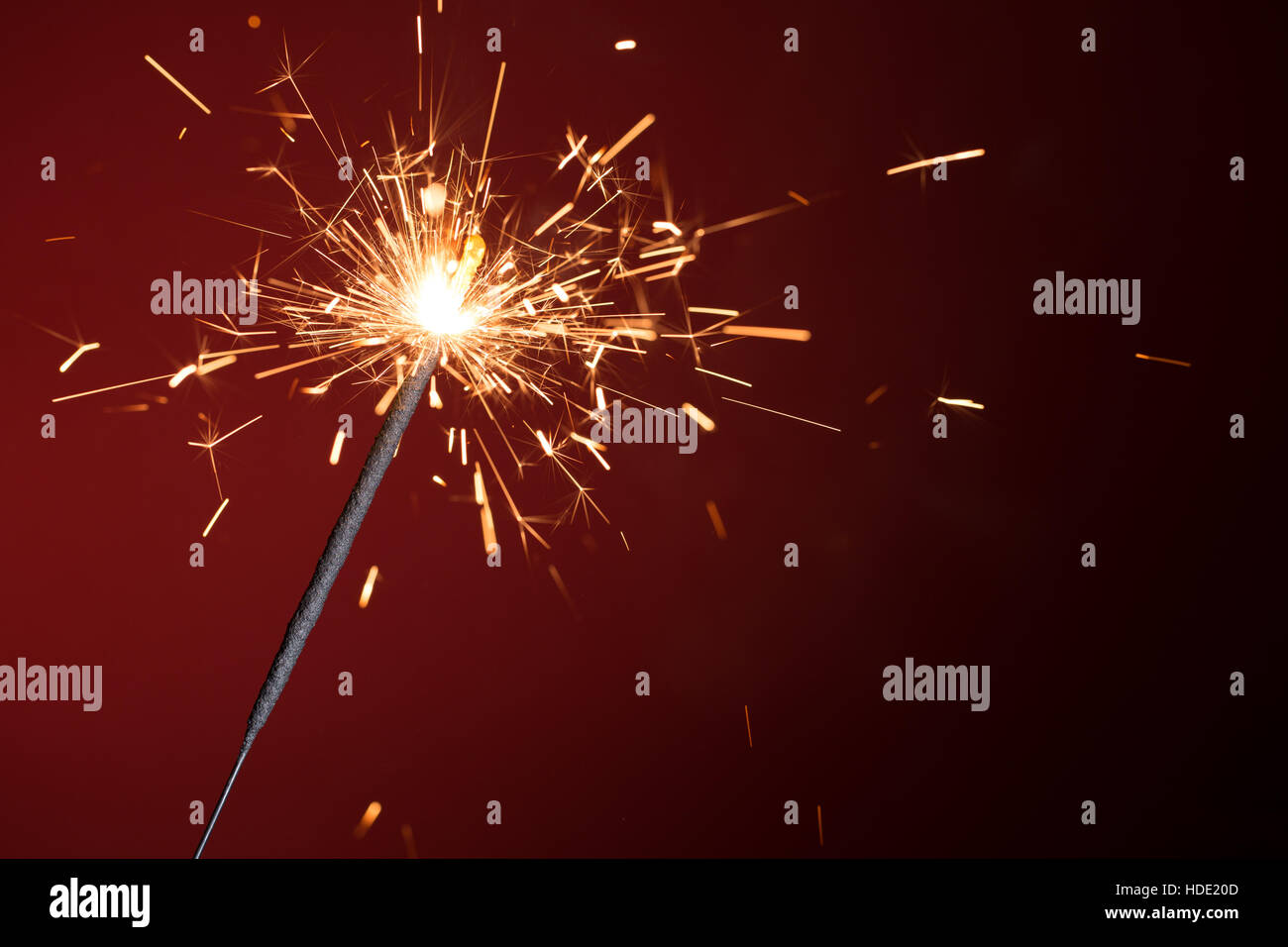 Christmas flaming bengal fire on red background blank Stock Photo - Alamy