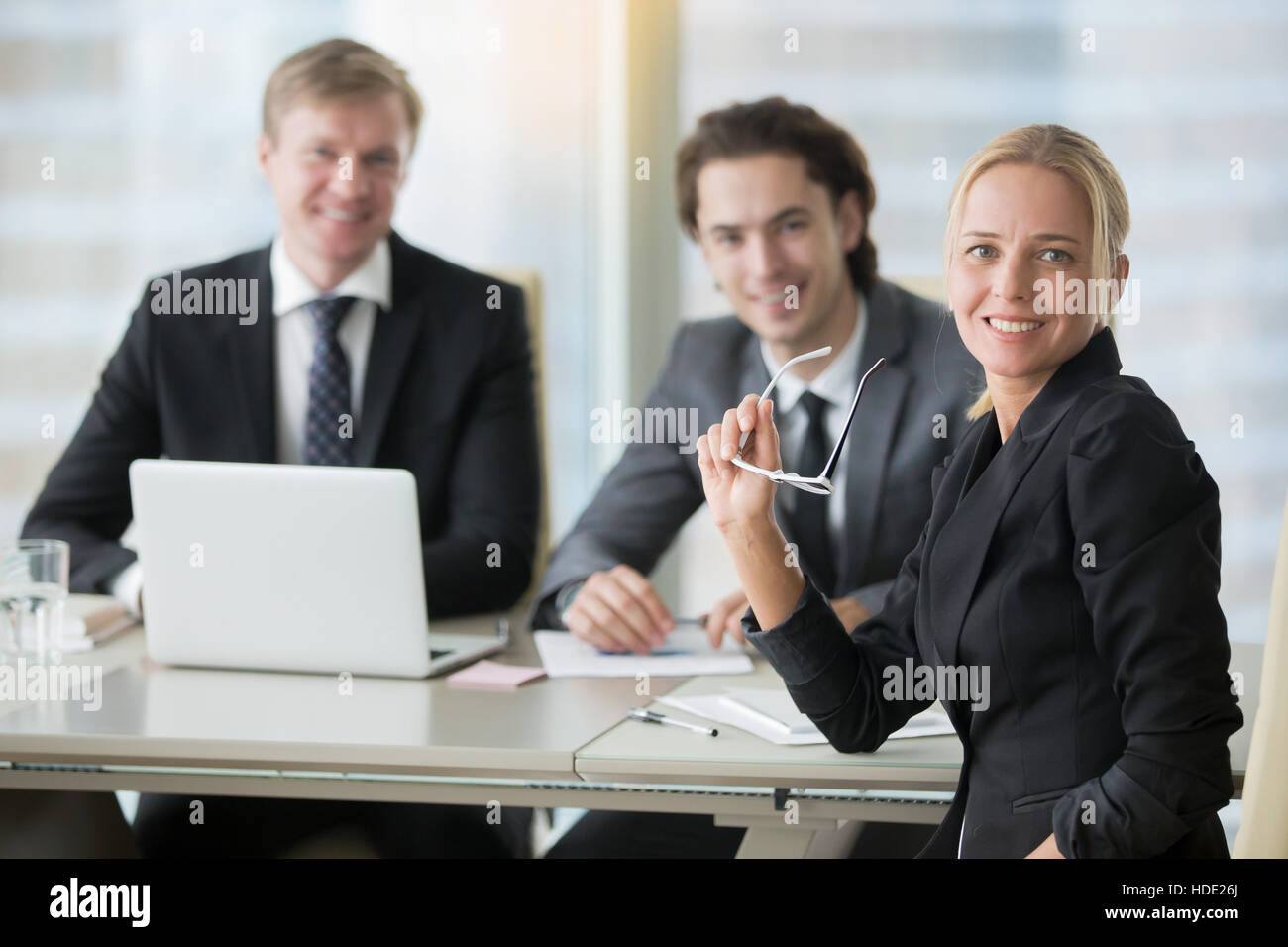 Group of smiling businessmen at the modern office desk Stock Photo - Alamy