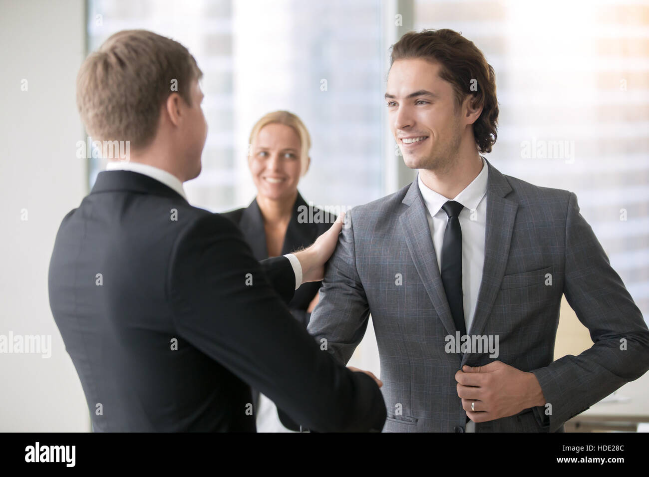 Two smiling businessmen handshaking Stock Photo - Alamy