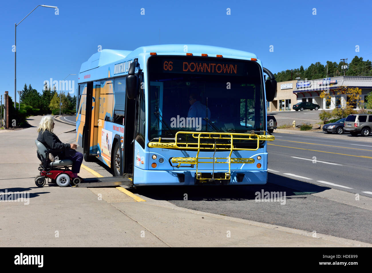 City bus with disabled person getting on, bike rack in front, USA ...