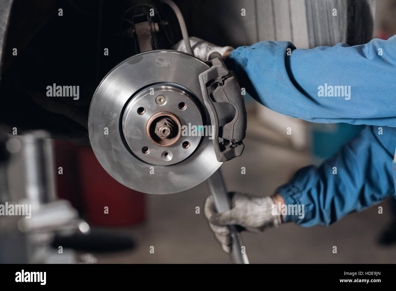 change the old drive to the Brand new brake disc on car in a garage ...