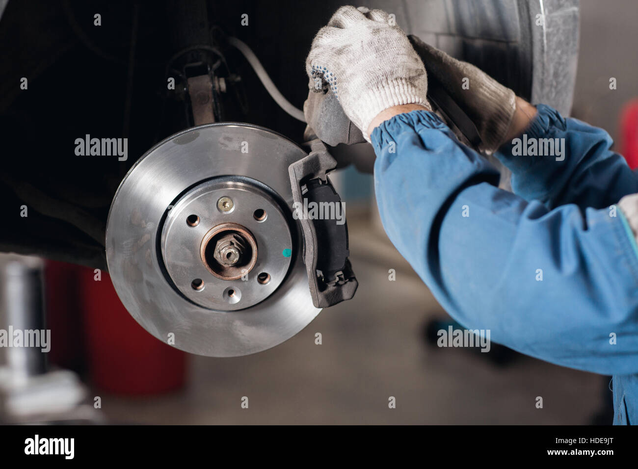 change the old drive to the Brand new brake disc on car in a garage ...