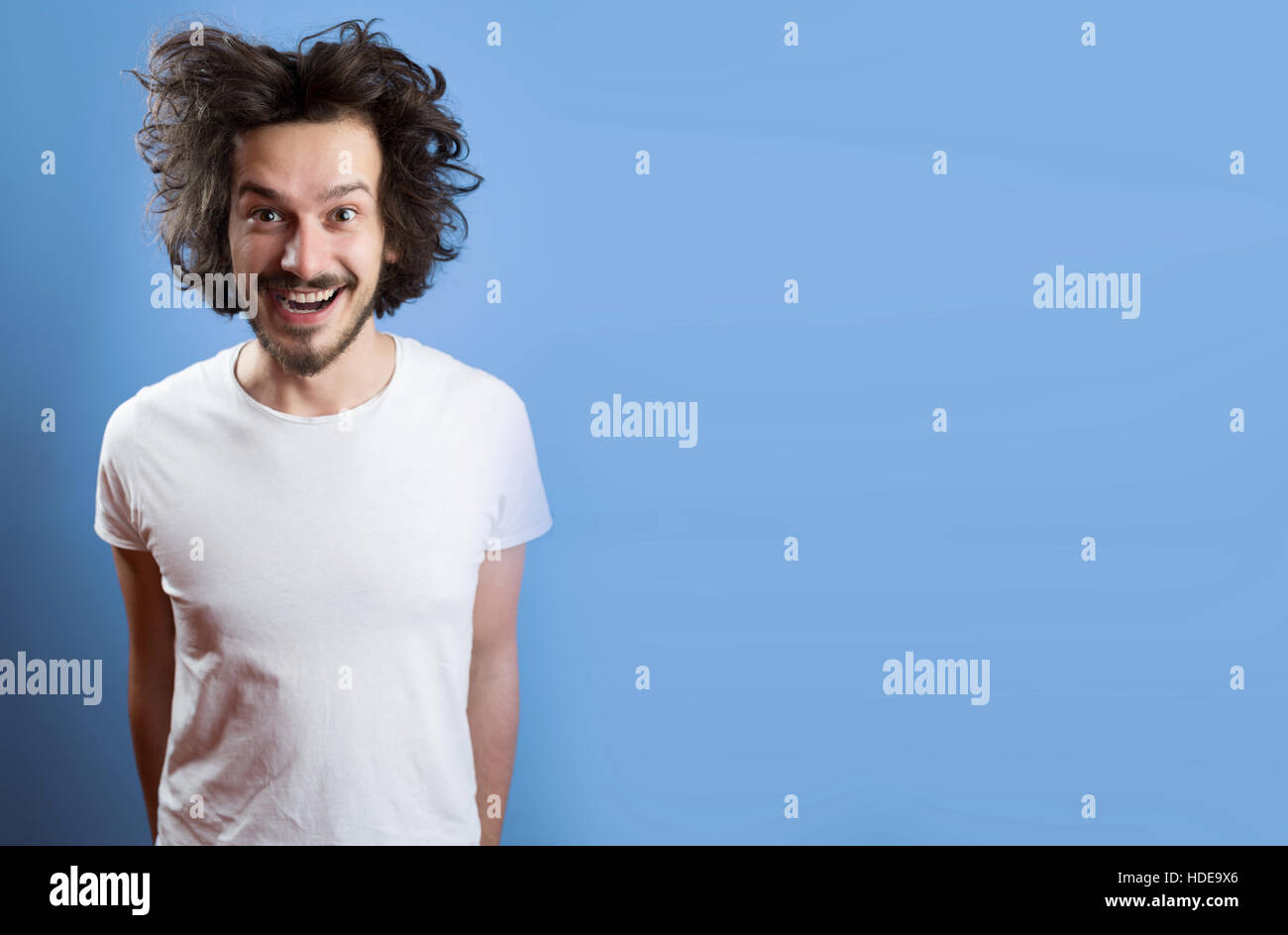 Beautiful caucasian man with funny hair over color background Stock ...