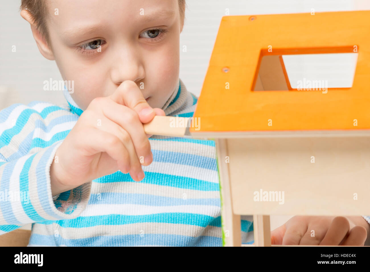 attentive boy preschooler tries to paint the bird feeder Stock Photo ...