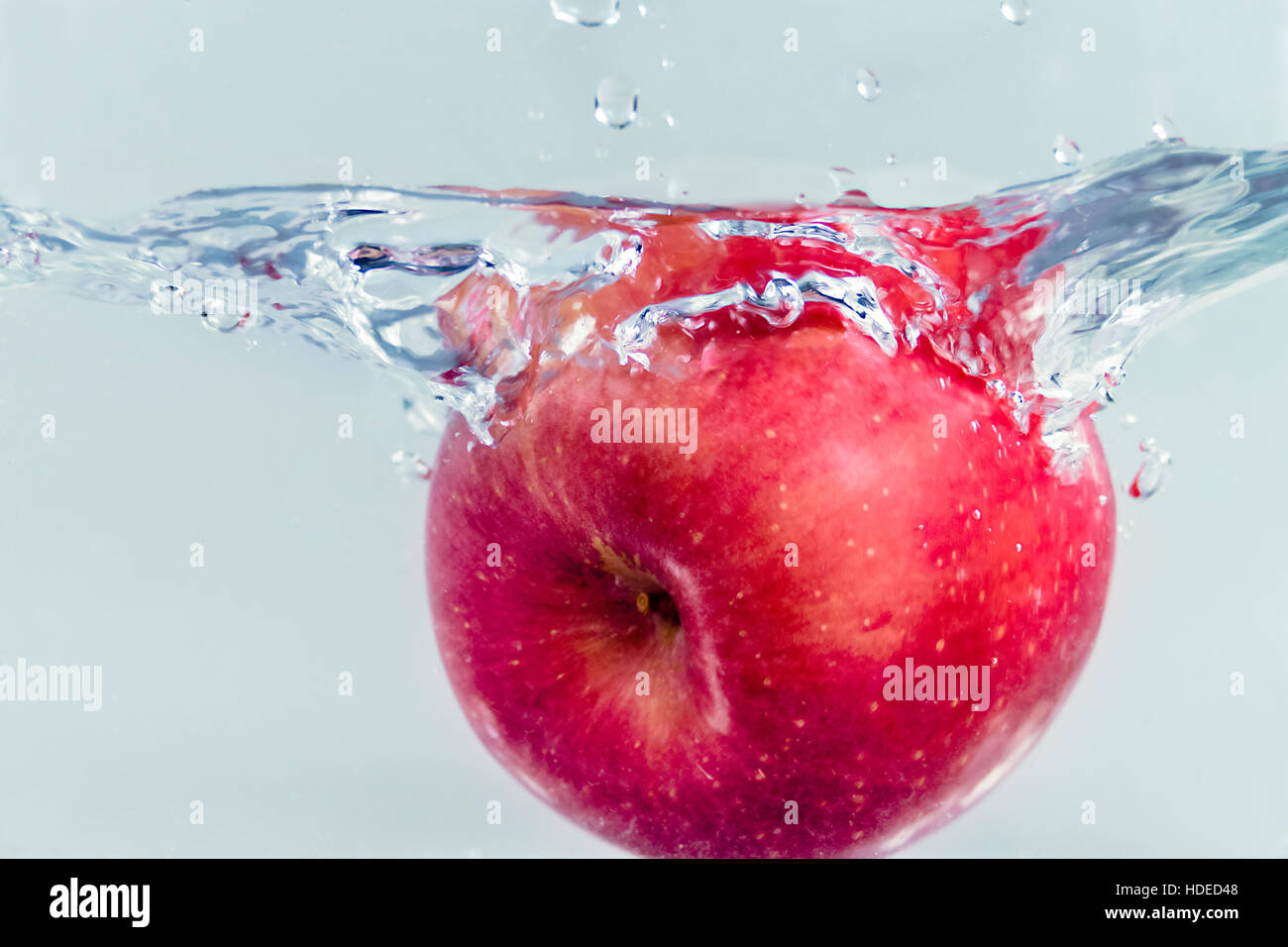Apple falling into water splashing Stock Photo - Alamy