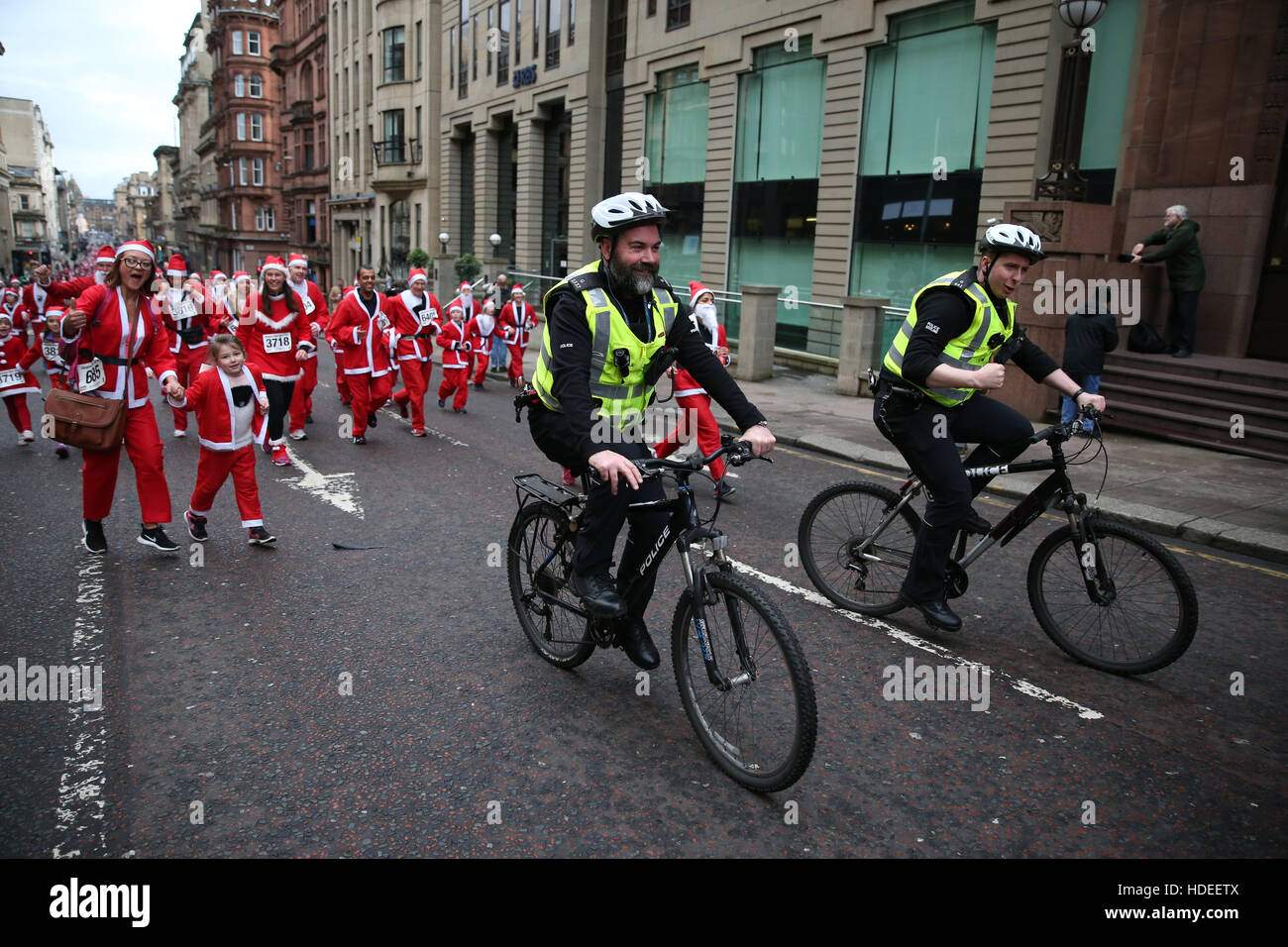 Police officers on bicycles alongside runners in Santa costumes taking ...