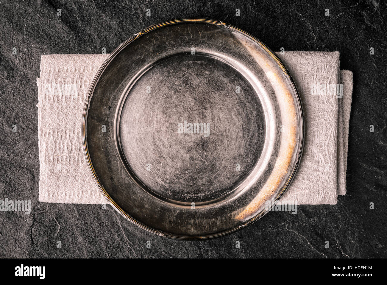 Old metal plate on the dark stone table top view Stock Photo - Alamy