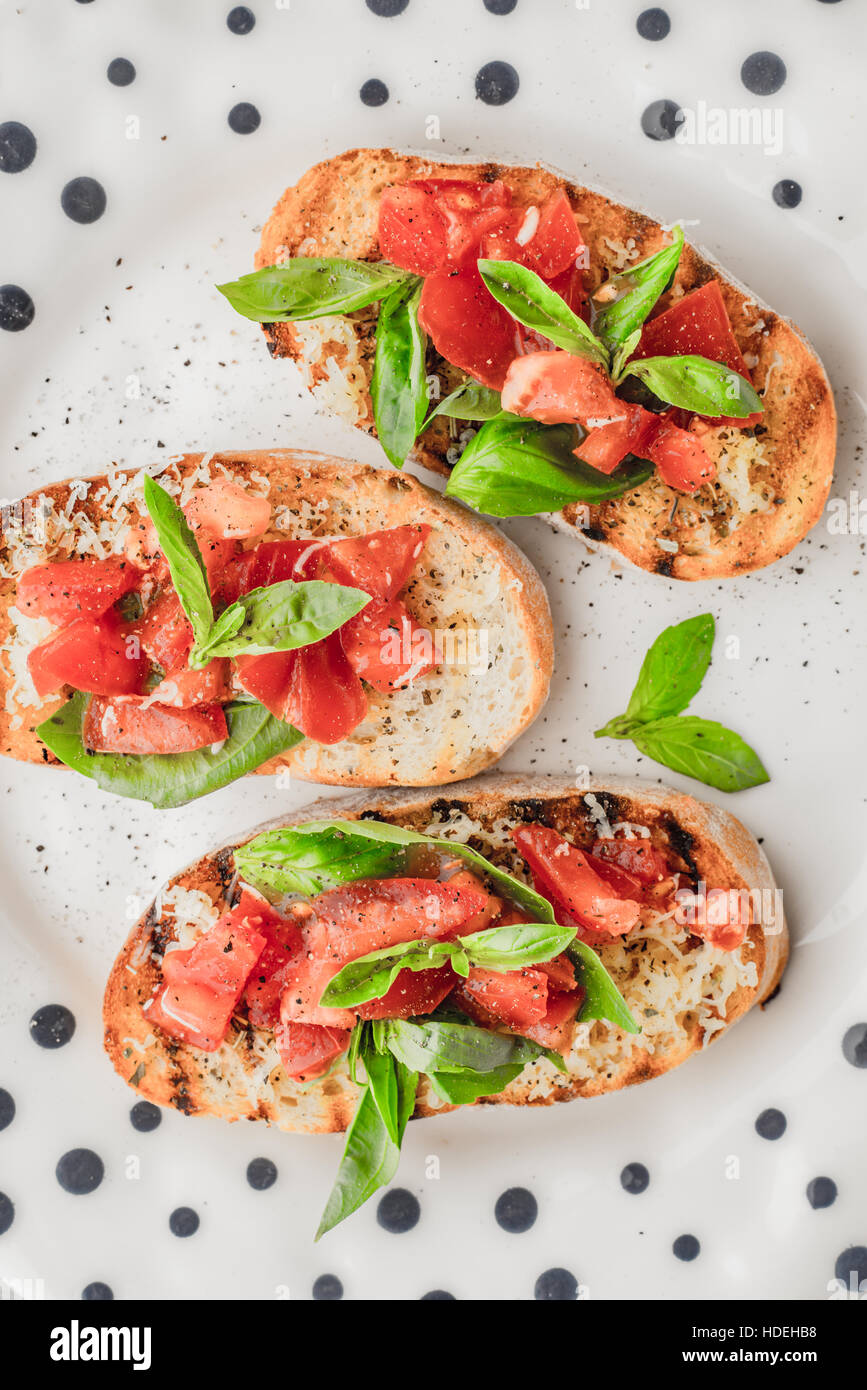 Bruschetta with tomatoes and basil on the ceramic plate Stock Photo - Alamy