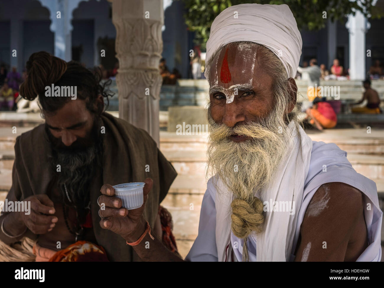 A sadhu, Hindu holy man, dressed in traditional garb enjoys a break and ...
