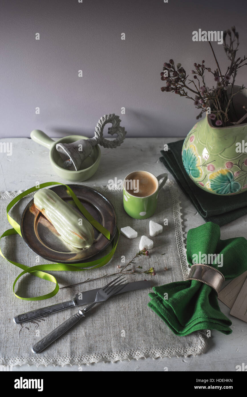 Eclair with green decorations on the table vertical Stock Photo - Alamy