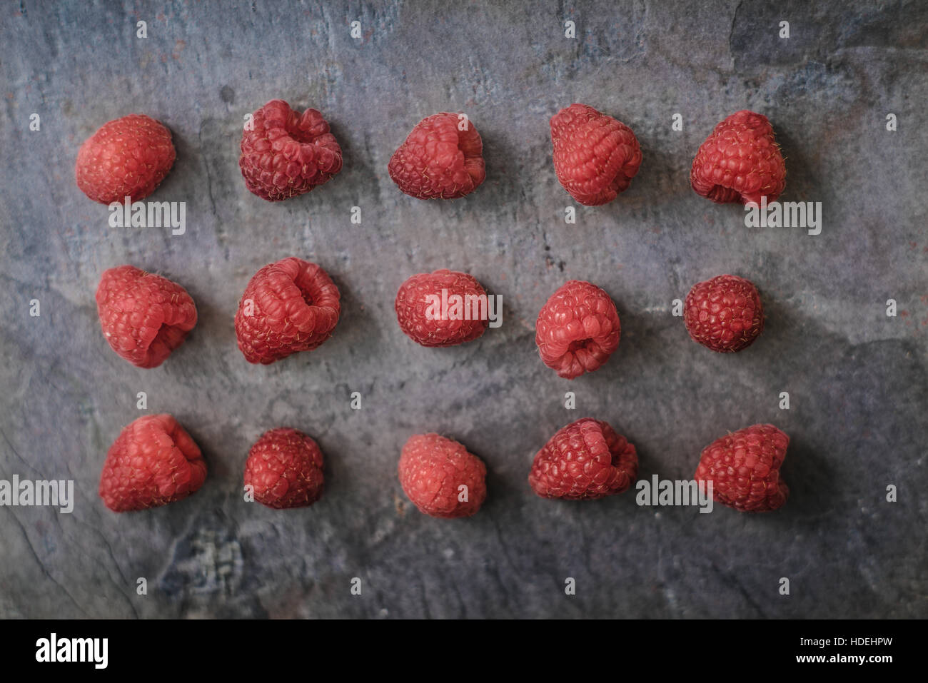 Raspberries on the dark stone background Stock Photo - Alamy