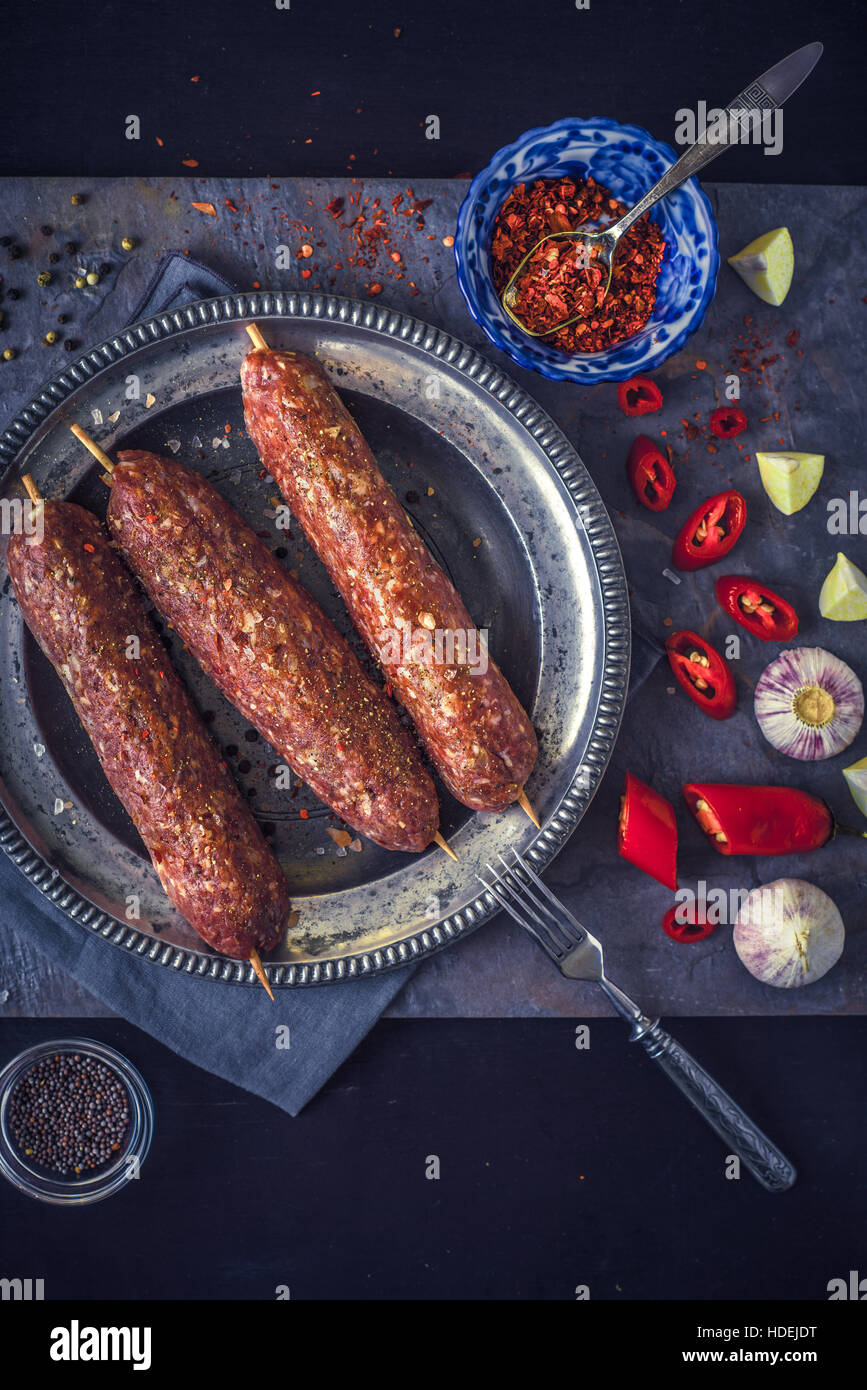 Raw kebabs with seasoning on the stone table vertical Stock Photo - Alamy