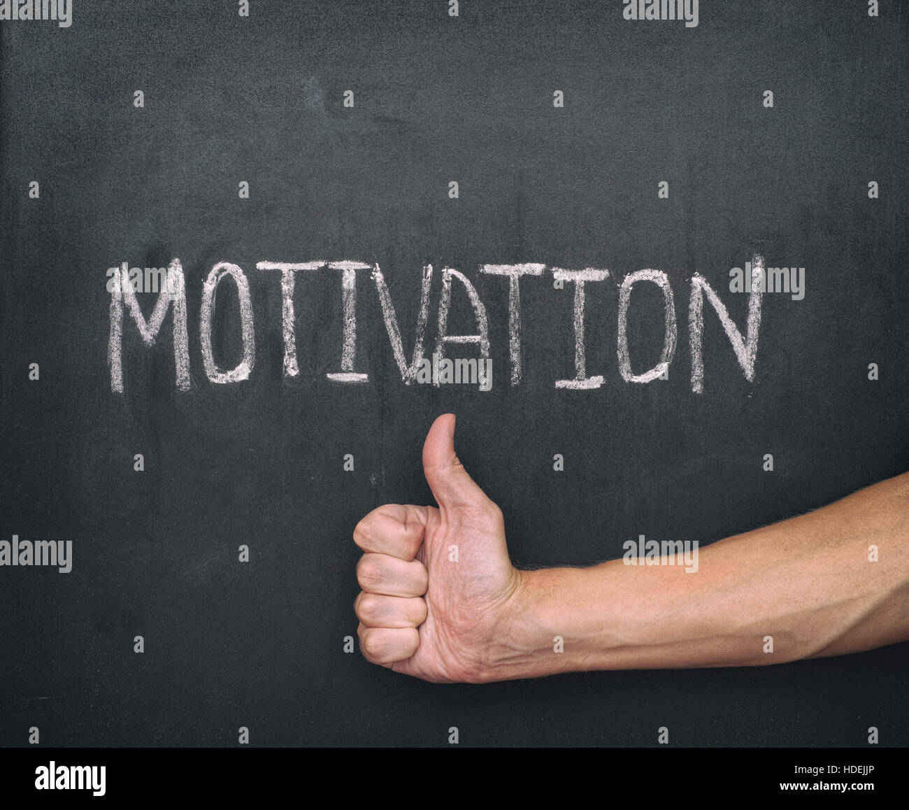 Thumb up below and word Motivation on blackboard Stock Photo - Alamy