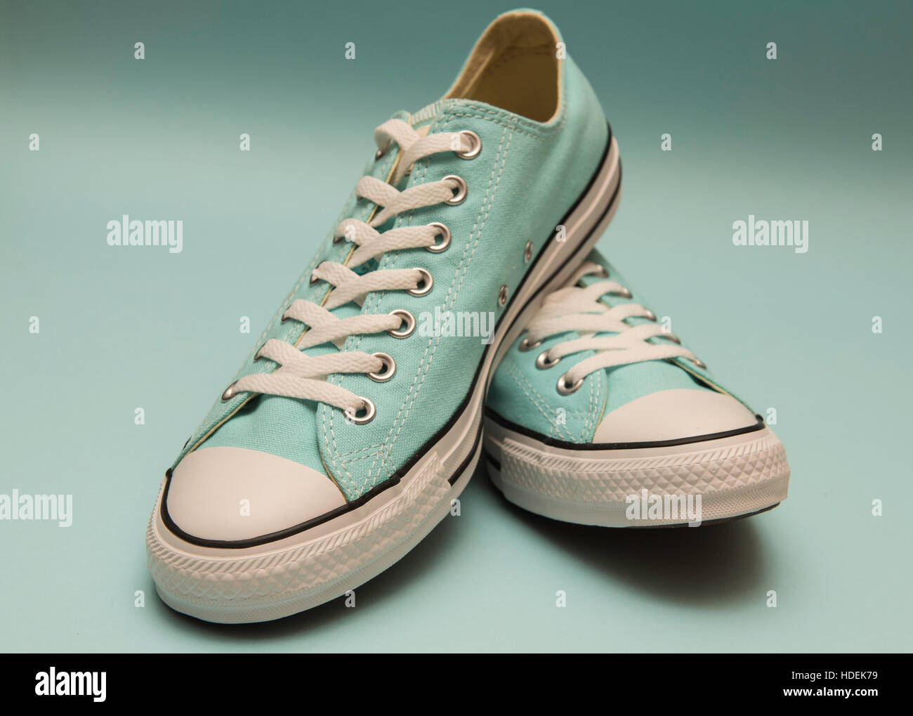 Turquoise sneakers on a blue background Stock Photo - Alamy