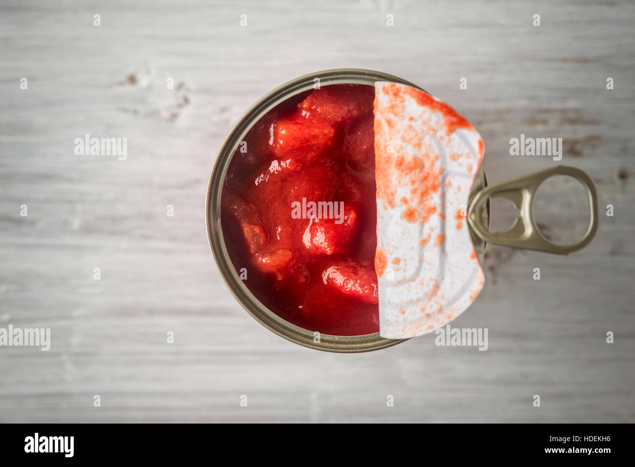 Chopped tomatoes in the metal can in the white wooden table top view ...