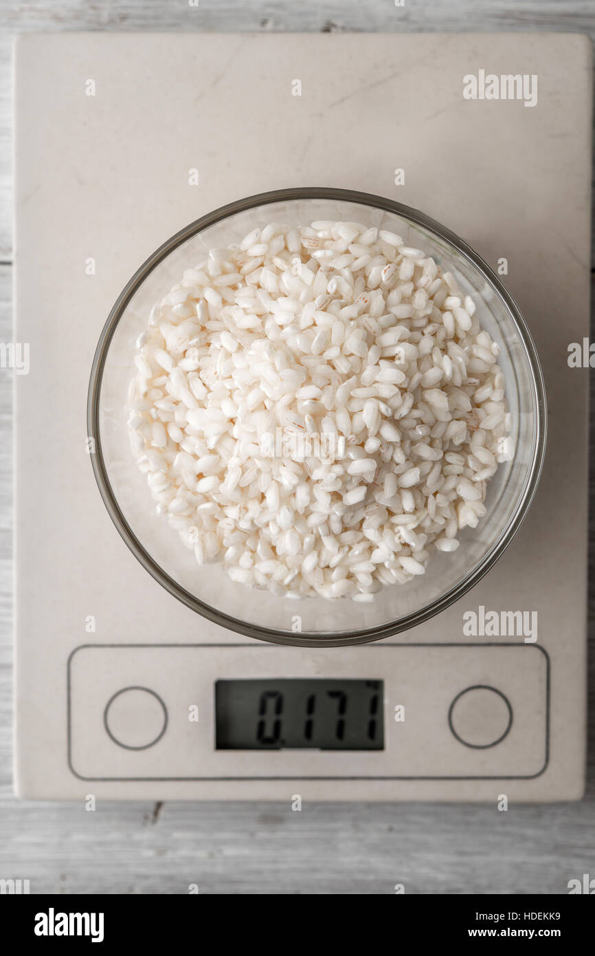 Rice in the glass bowl on the scale vertical Stock Photo - Alamy