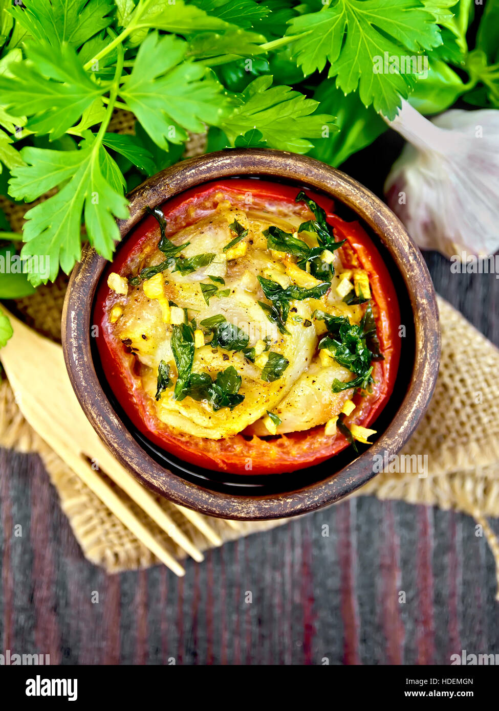 Fish baked in tomato in Zandvoort in clay bowl on a napkin of burlap ...