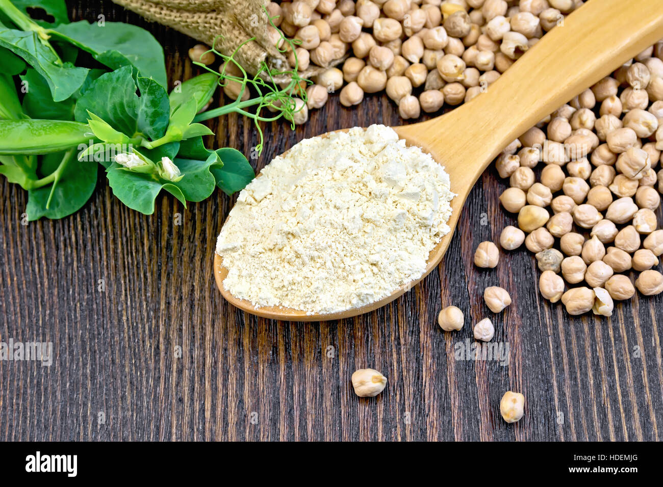 Flour chickpeas in spoonful, chick-peas in a sack and fresh pea pods on ...