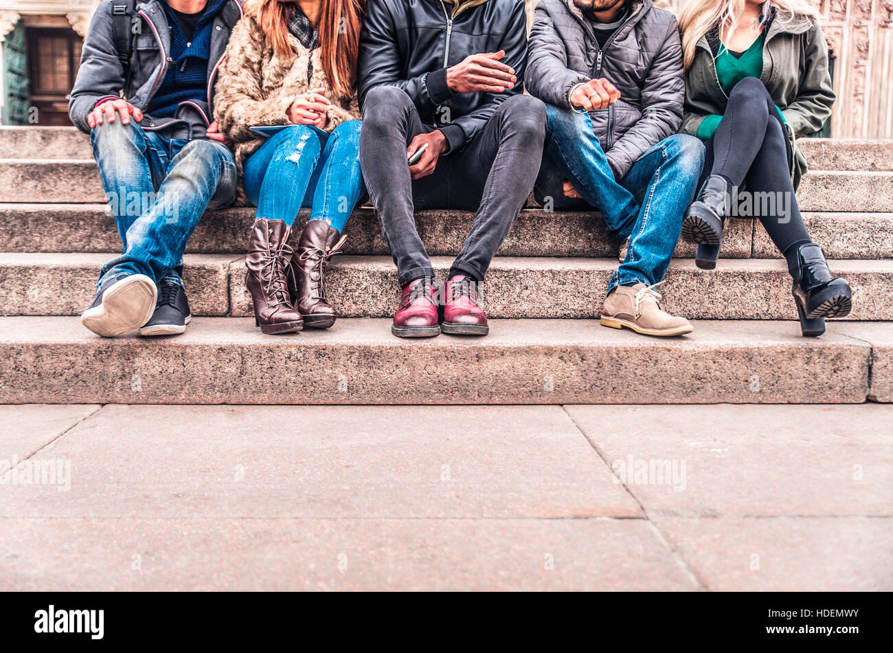Group of people sitting on a staircase outdoors, close up on low ...