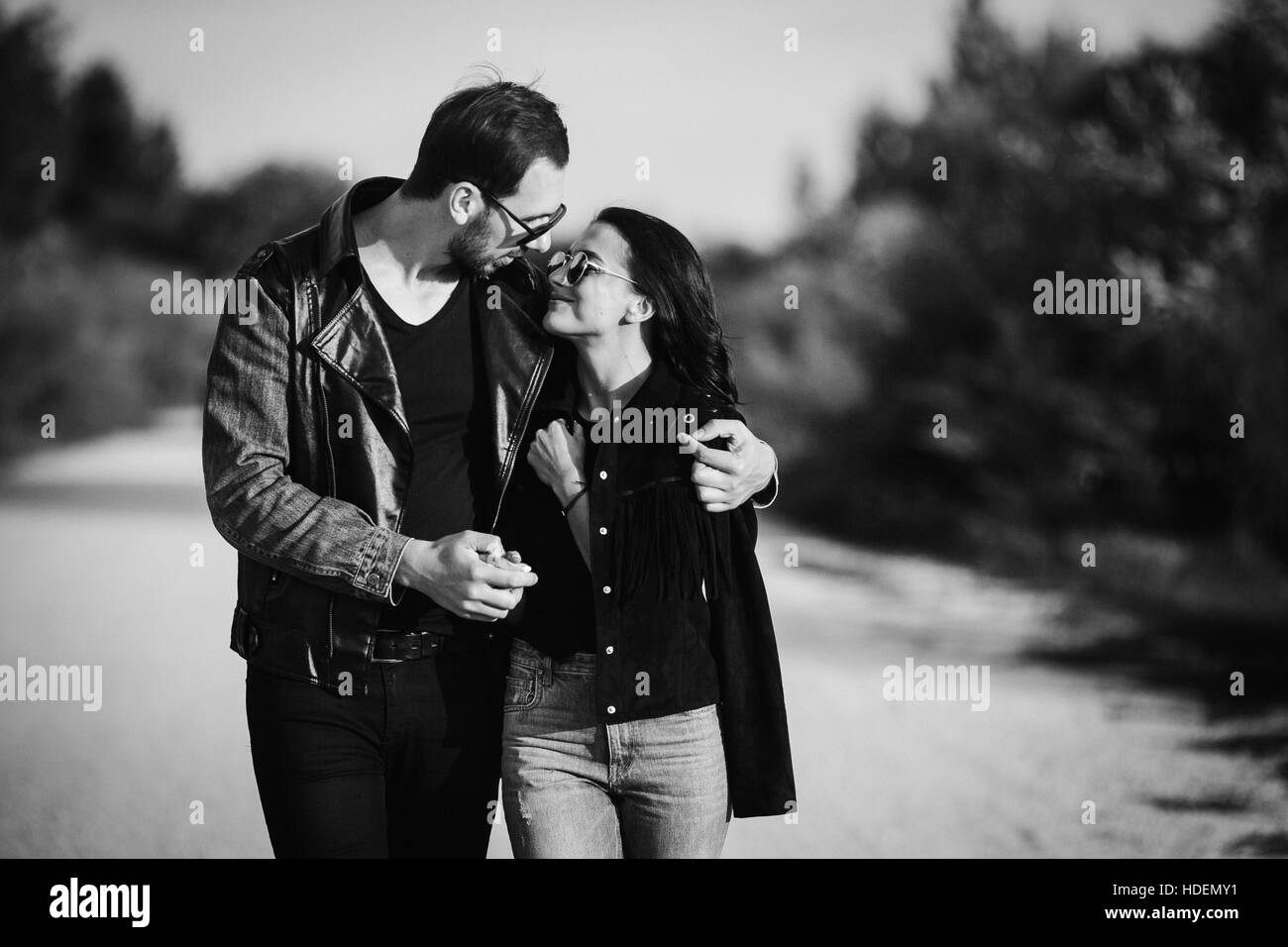 Young happy romantic couple walking along road Stock Photo - Alamy