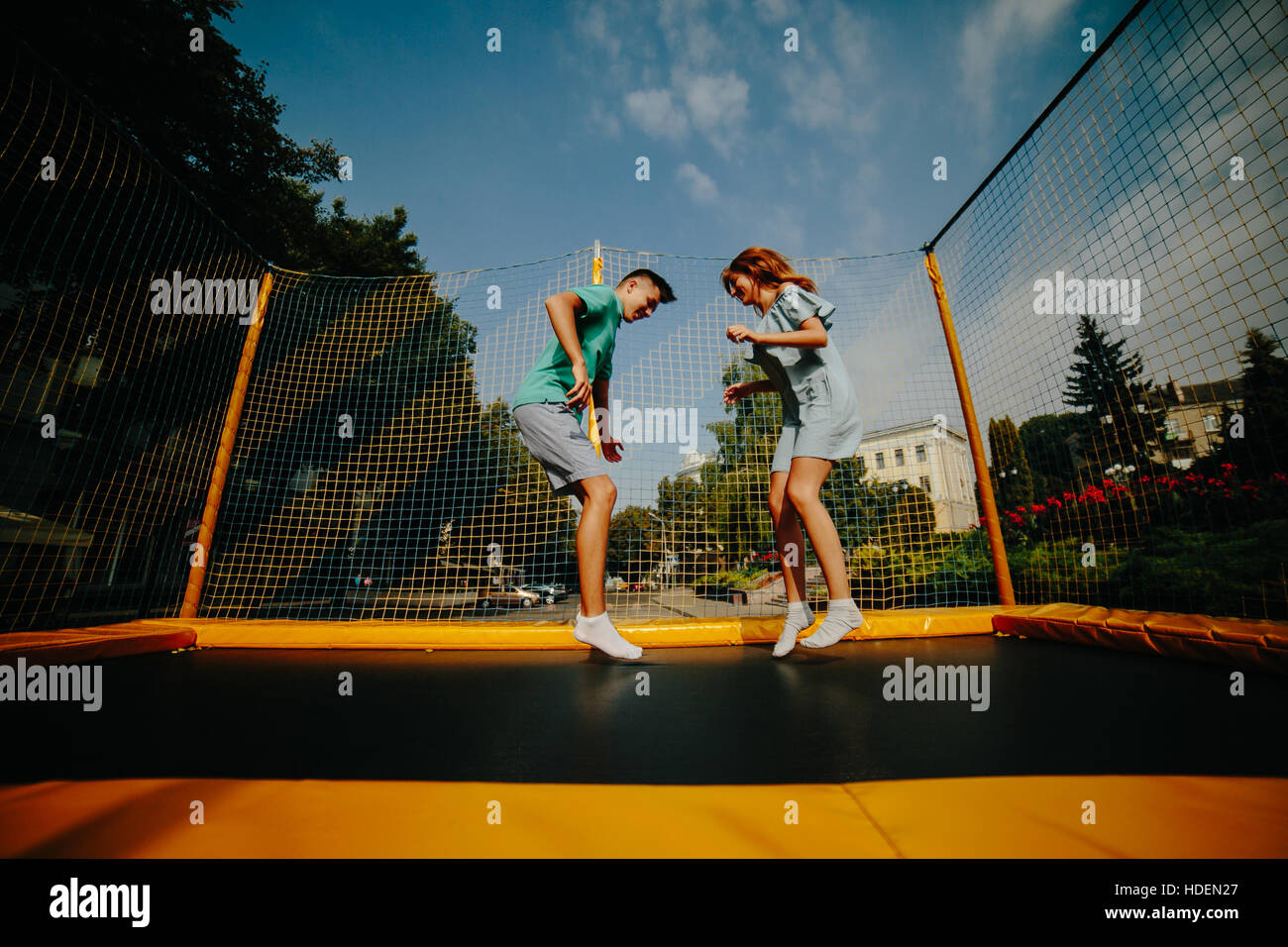 Couple jumping on trampoline in the park Stock Photo - Alamy