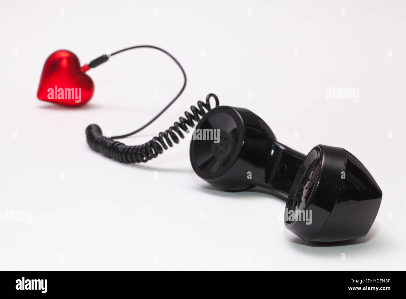 Old phone reciever and cord connection with red heart. Love hotline ...
