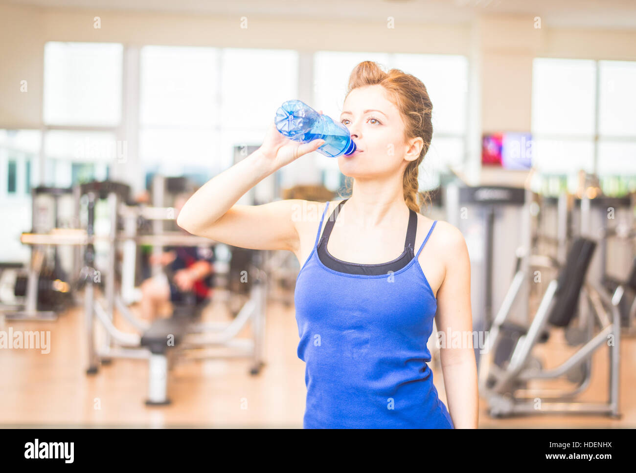 Sportive woman drinking water in a fitness gym club - Athletic girl ...