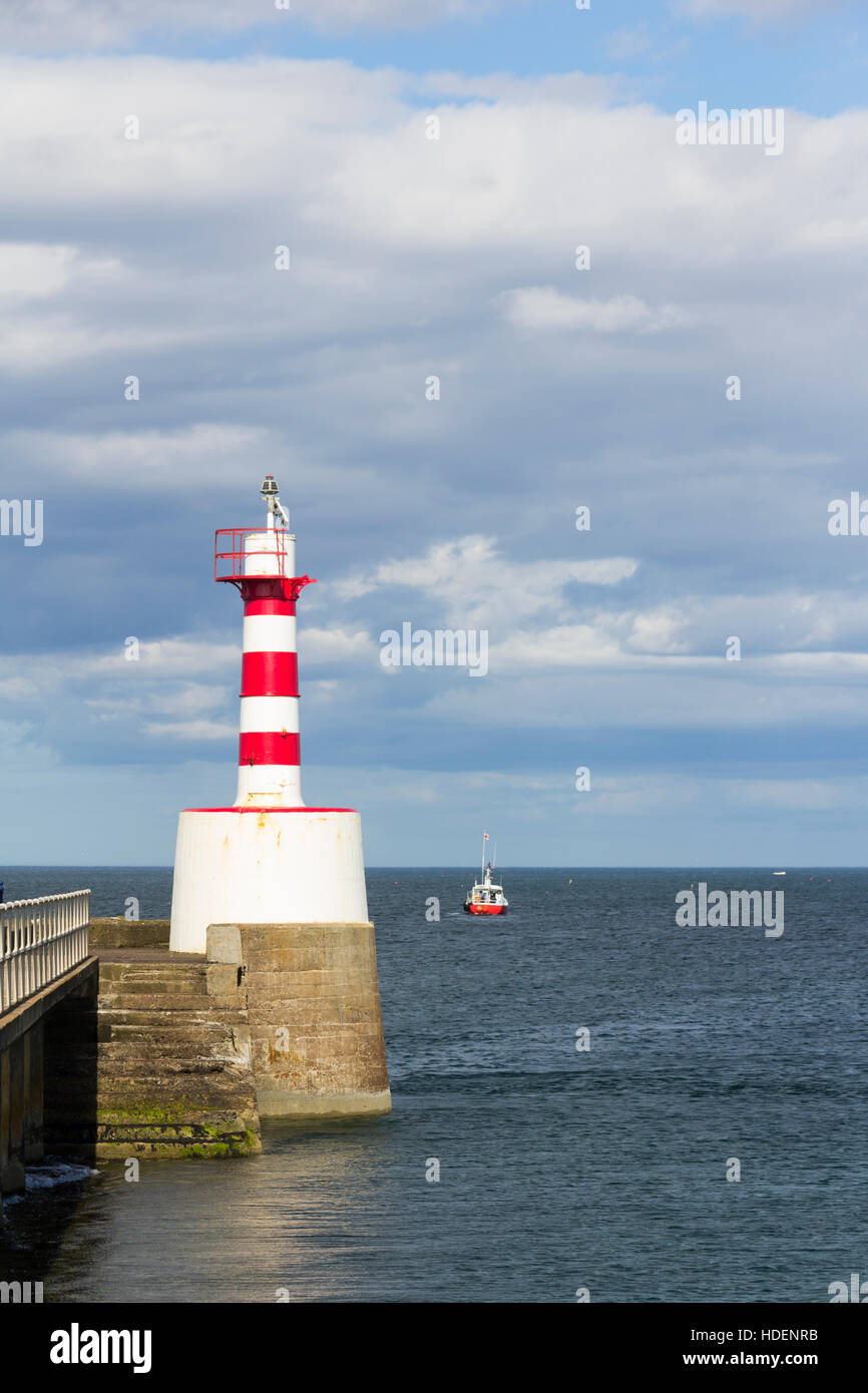 Lighthouse at the end of Amble pier, Northumberland, at the entrance to ...