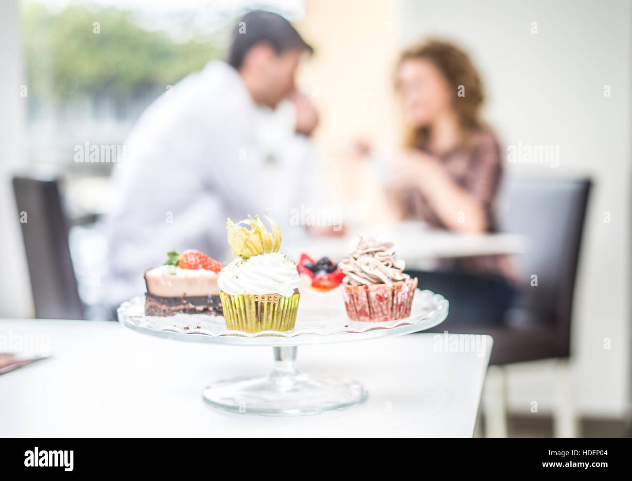 Couple meet in a restaurant cafe' to drink and eat pastry cakes Stock ...