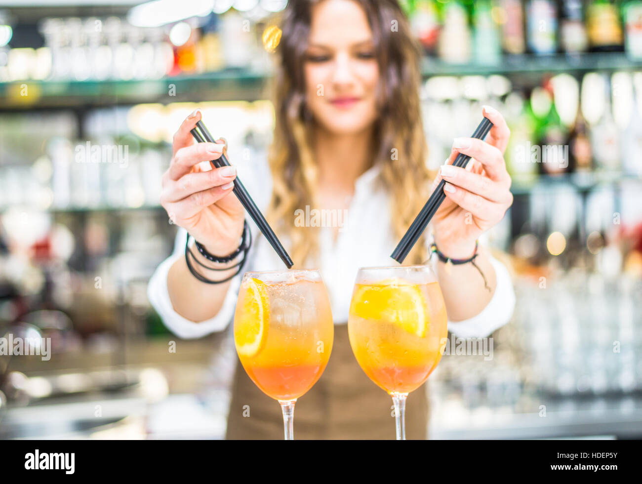Barmaid preparing cocktails in a bar for her clients - Bartender at ...