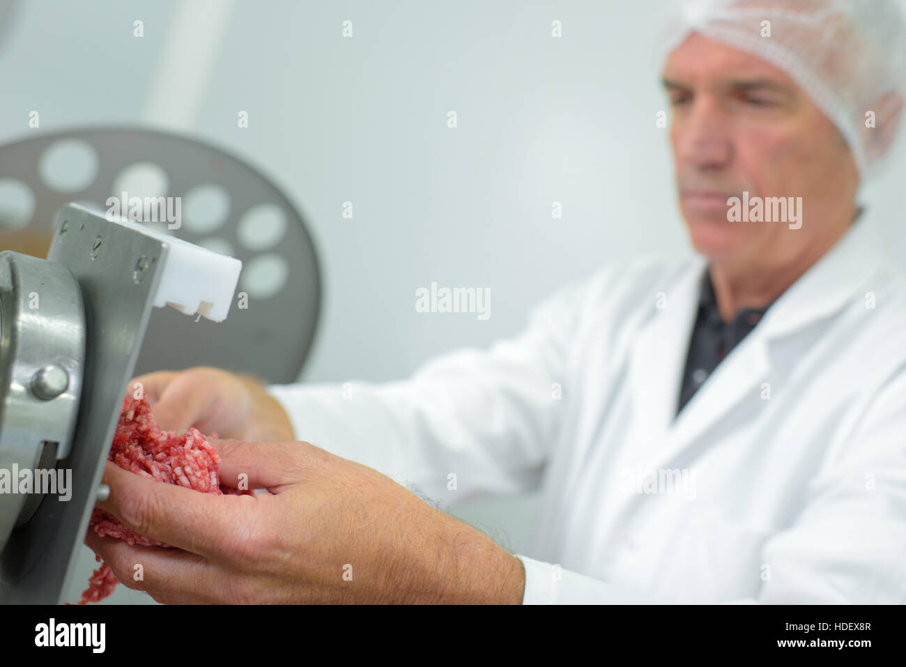Man mincing meat Stock Photo - Alamy