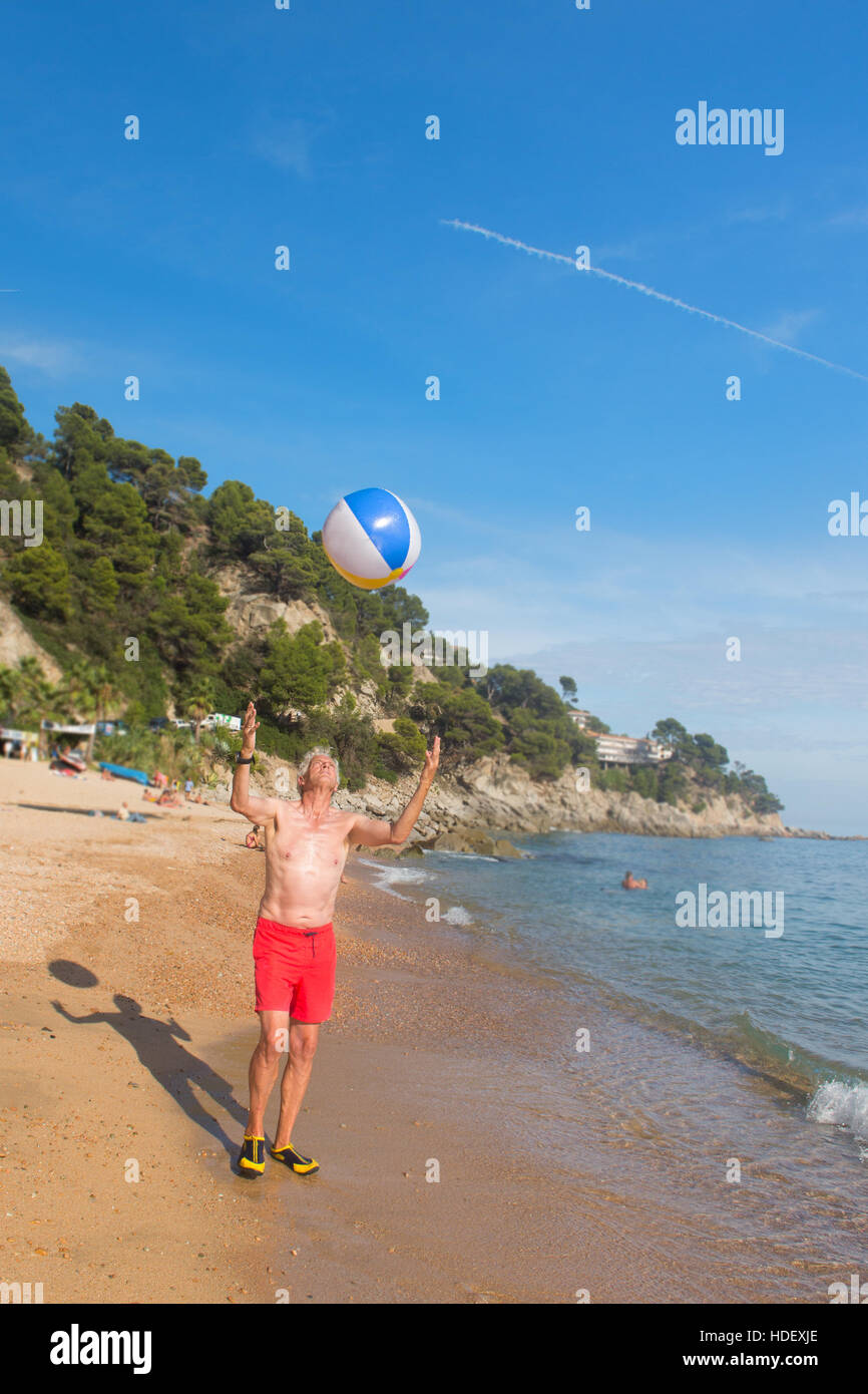 Man playing with inflatable ball at the beach Stock Photo - Alamy