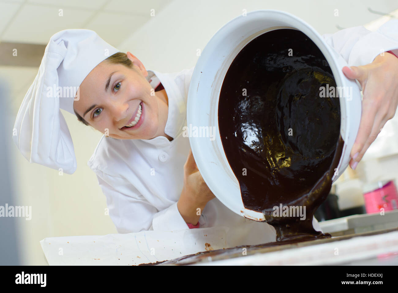 Chef pouring chocolate from bowl Stock Photo - Alamy