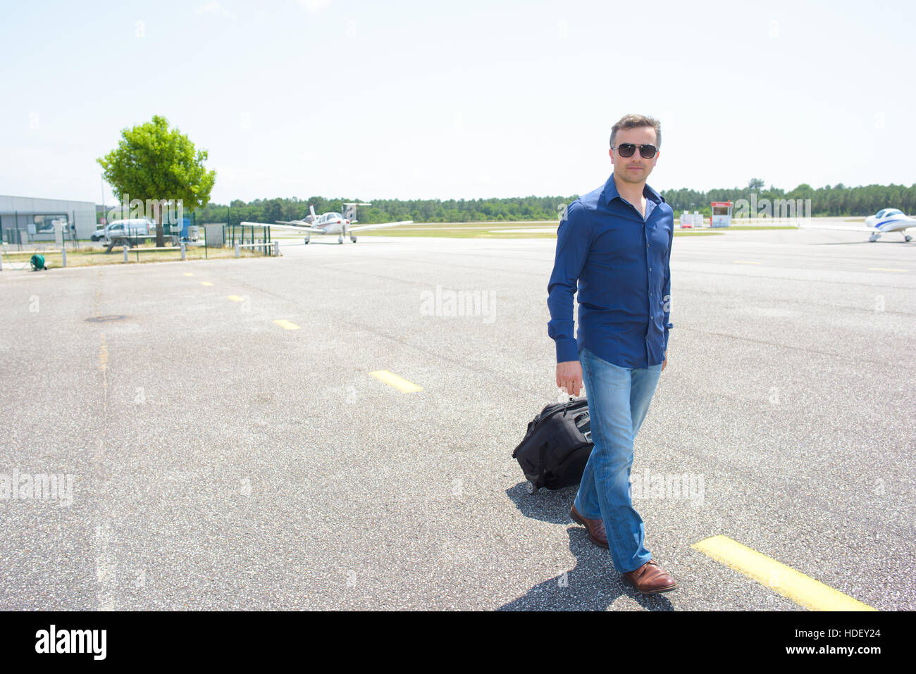 Man with suitcase at airport Stock Photo - Alamy