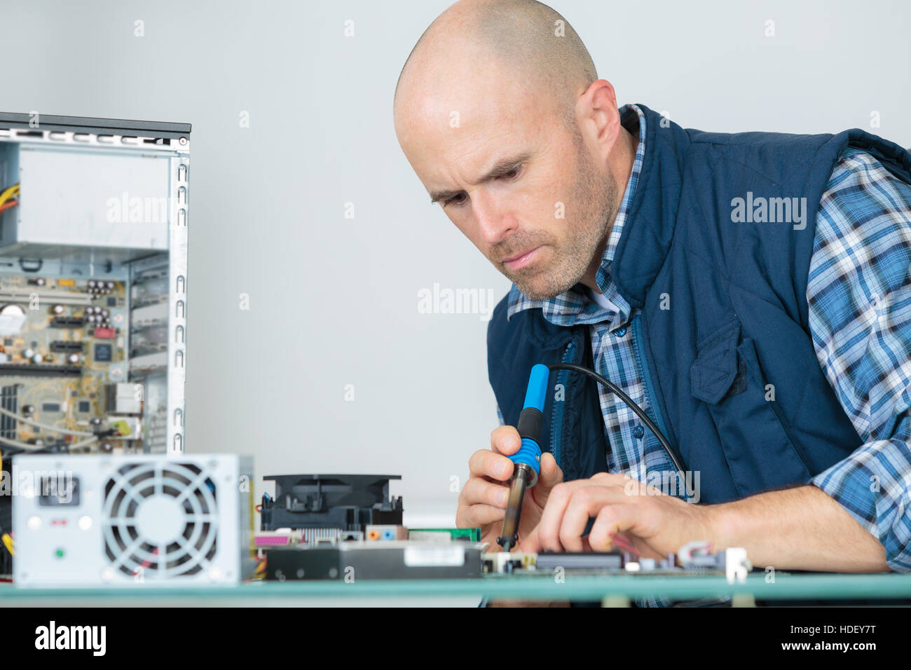 Computer repairman using soldering iron Stock Photo - Alamy
