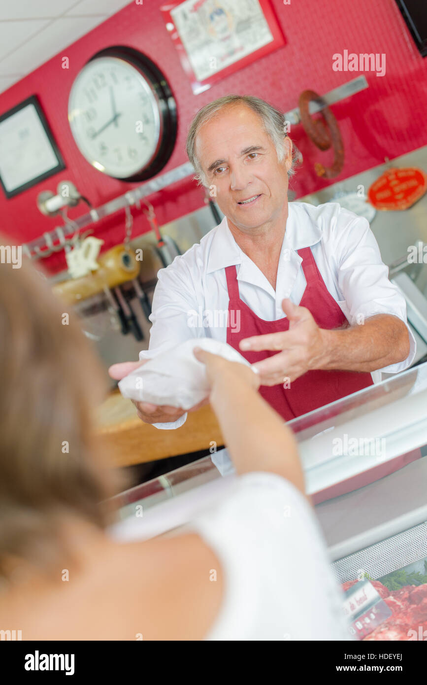 Butcher serving customer over counter Stock Photo - Alamy