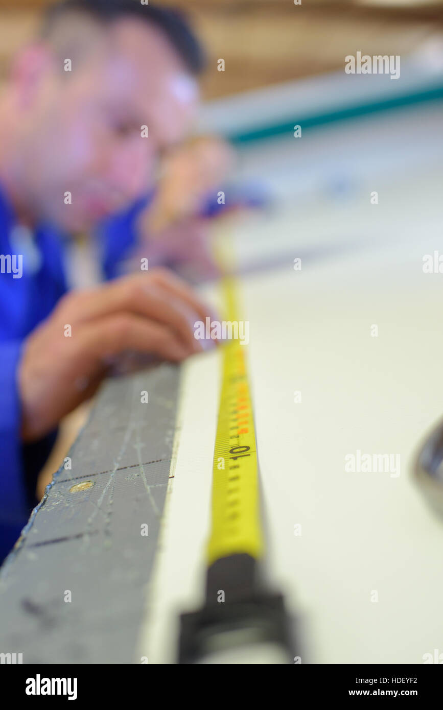Worker using tape measure Stock Photo - Alamy