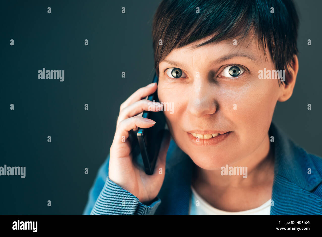 Businesswoman using mobile phone for business conversation in the ...